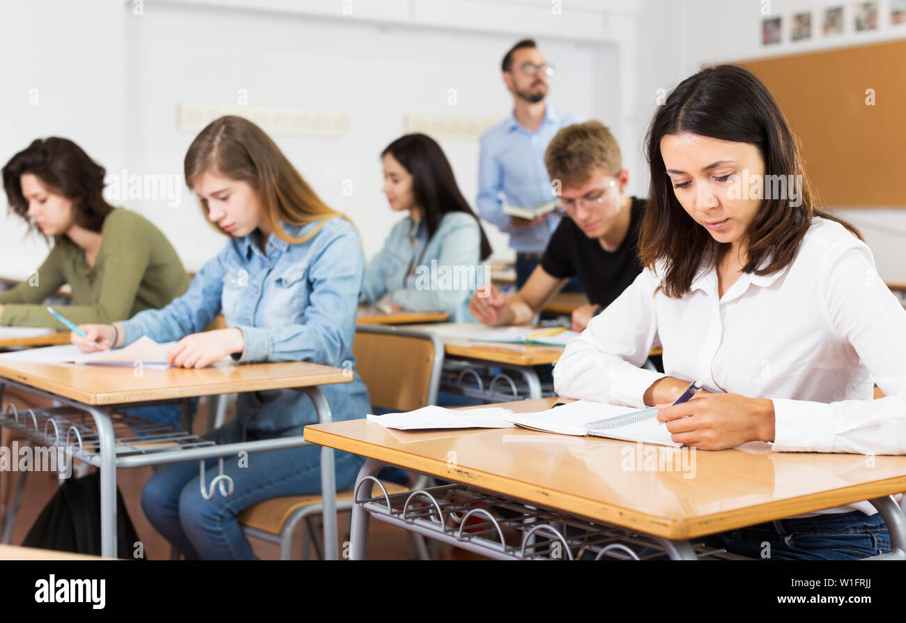 Young positive girl is learning and answering the question on paper in ...