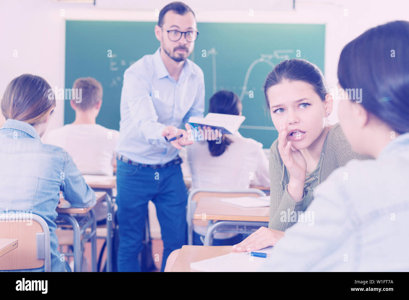 Girl books talking teacher hi-res stock photography and images - Alamy