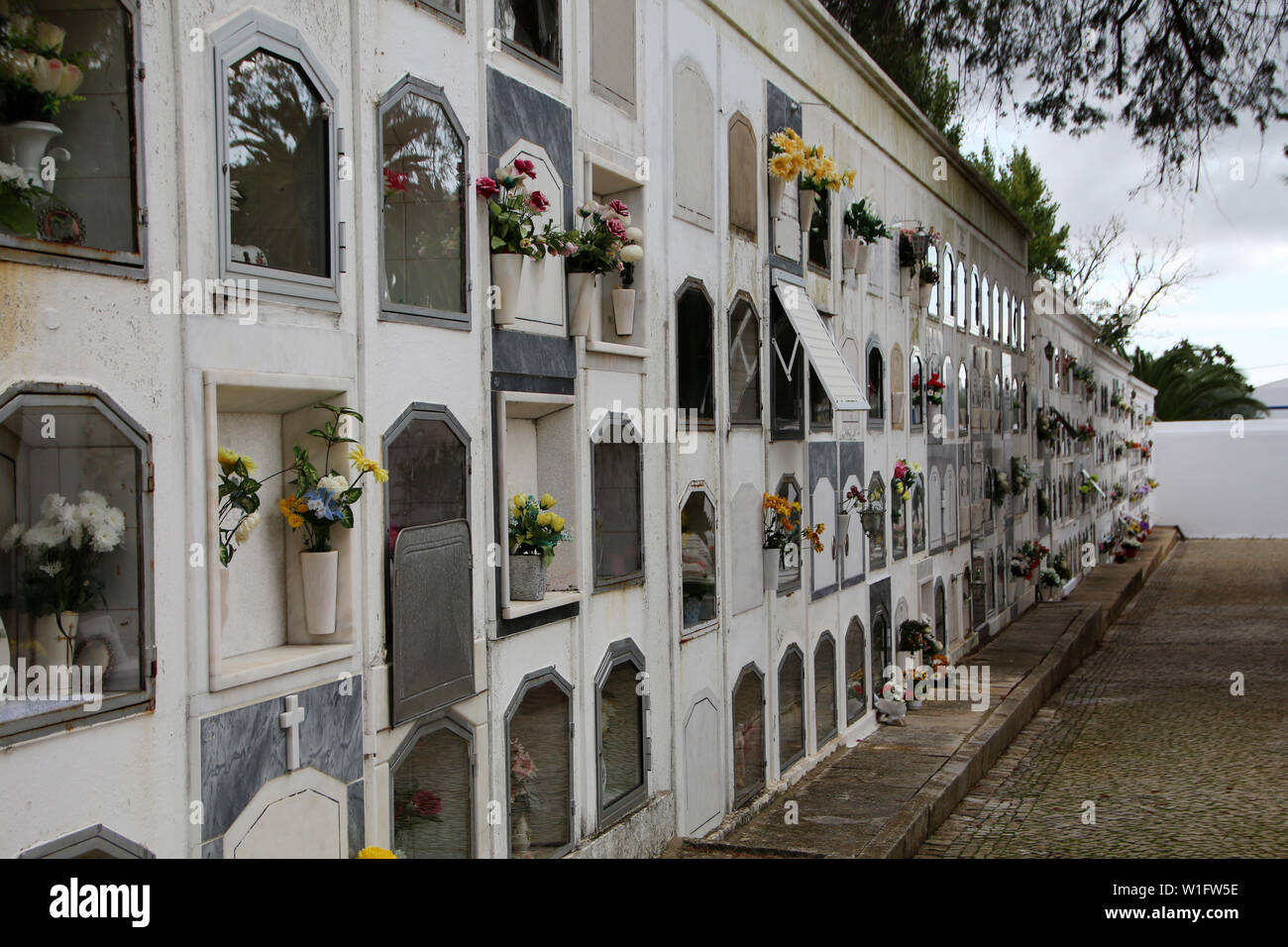 Wide view of a cemetary with a row of small cases to honor the deceased ...