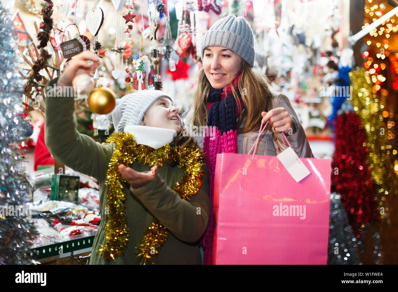 Woman and her daughter are preparing for Christmas and choosing balls ...