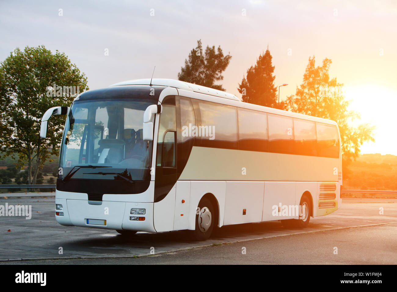 Passenger Bus parked on the road at sunrise Stock Photo - Alamy