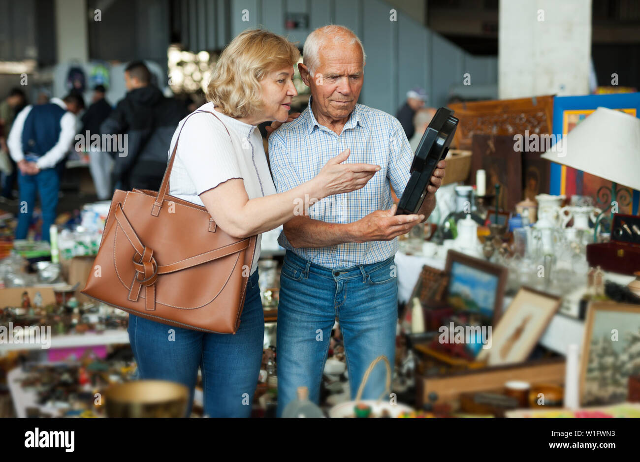 Mature man and his wife are visiting market of old things Stock Photo ...
