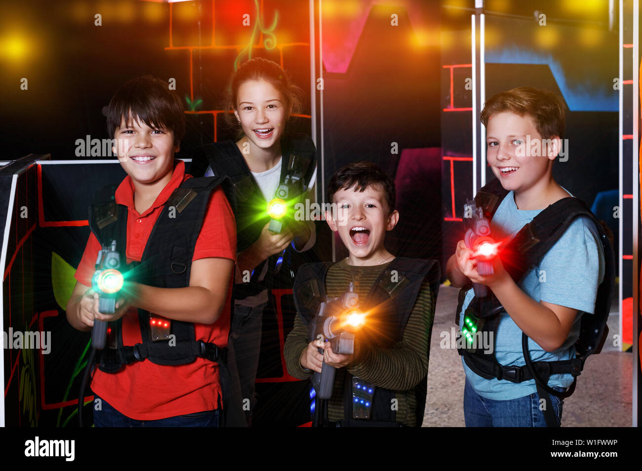 Portrait of happy excited teen kids with laser guns during lasertag ...