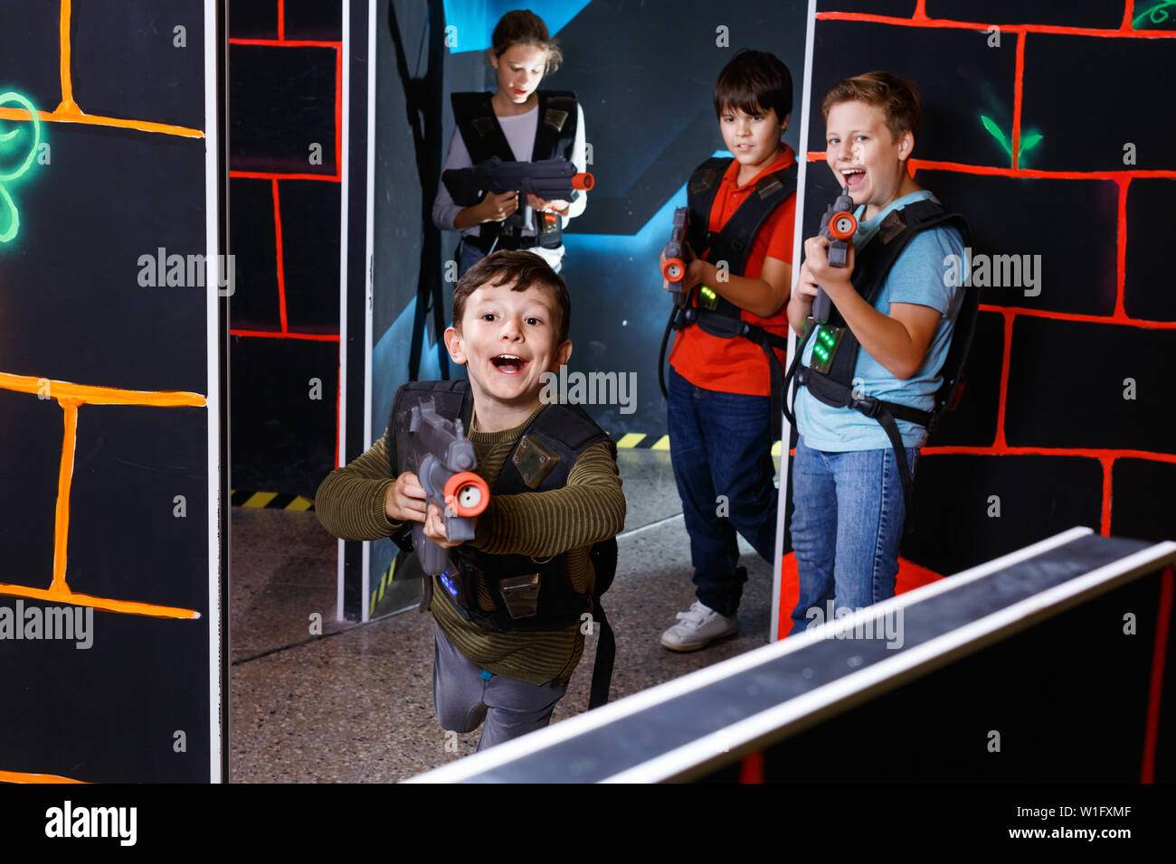 Emotional happy cheerful positive teen boy with laser pistol playing ...