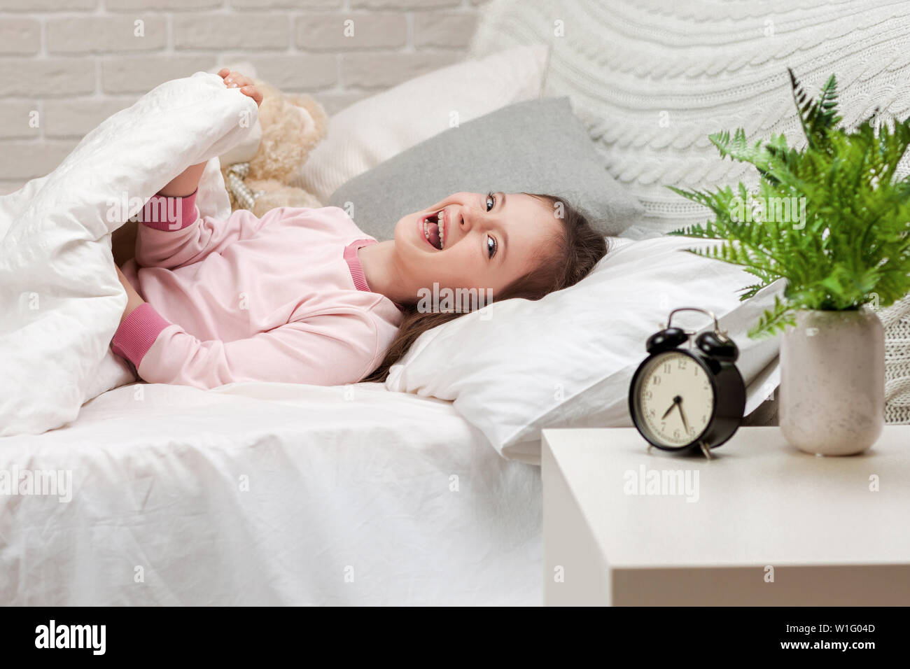 cute little child girl wakes up from sleep in bed in the morning Stock ...