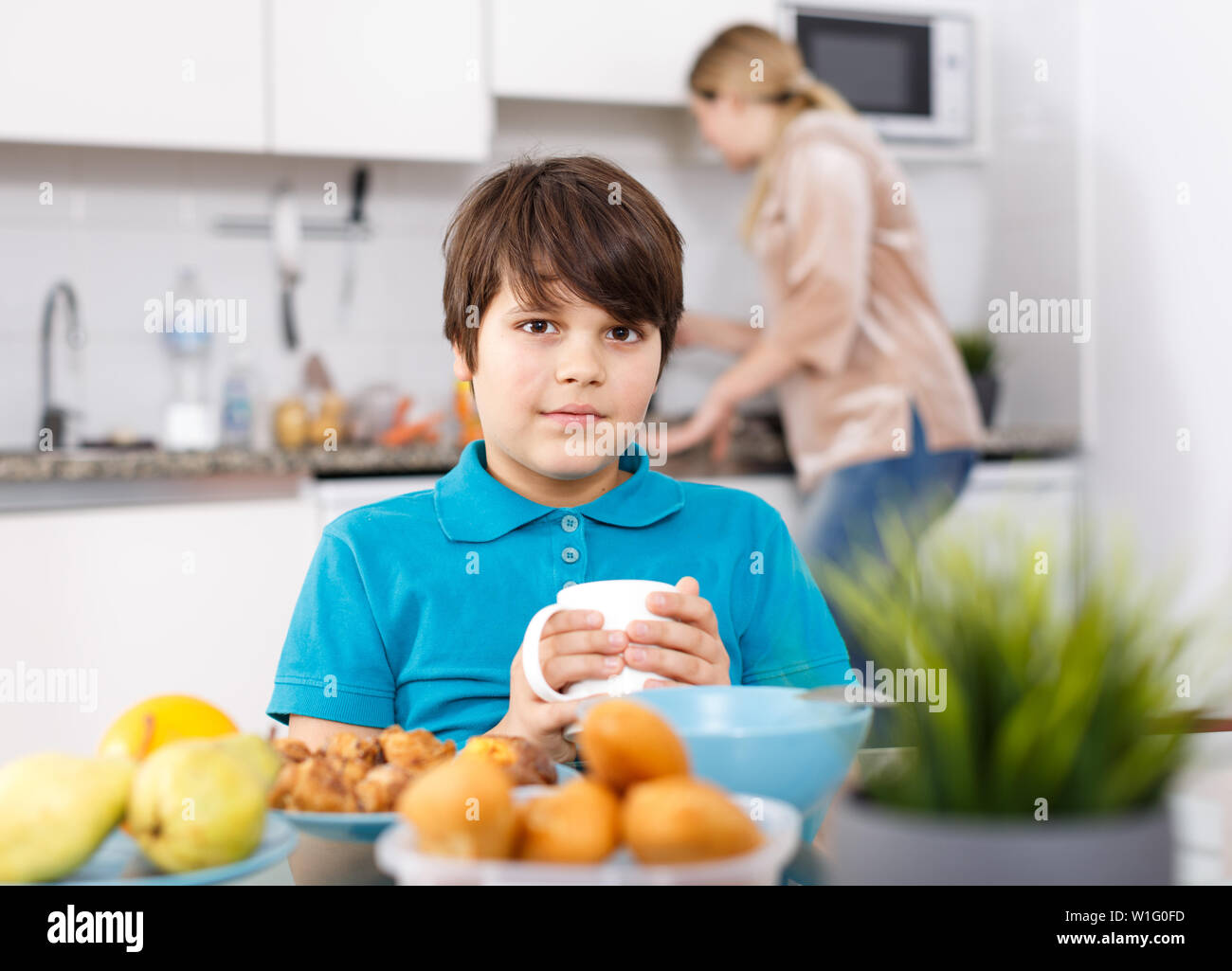 Portrait of tweenage boy having breakfast at kitchen at home Stock ...