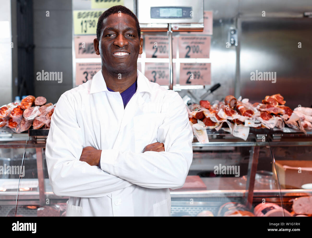 Confident happy cheerful male owner of butcher shop standing with arms ...