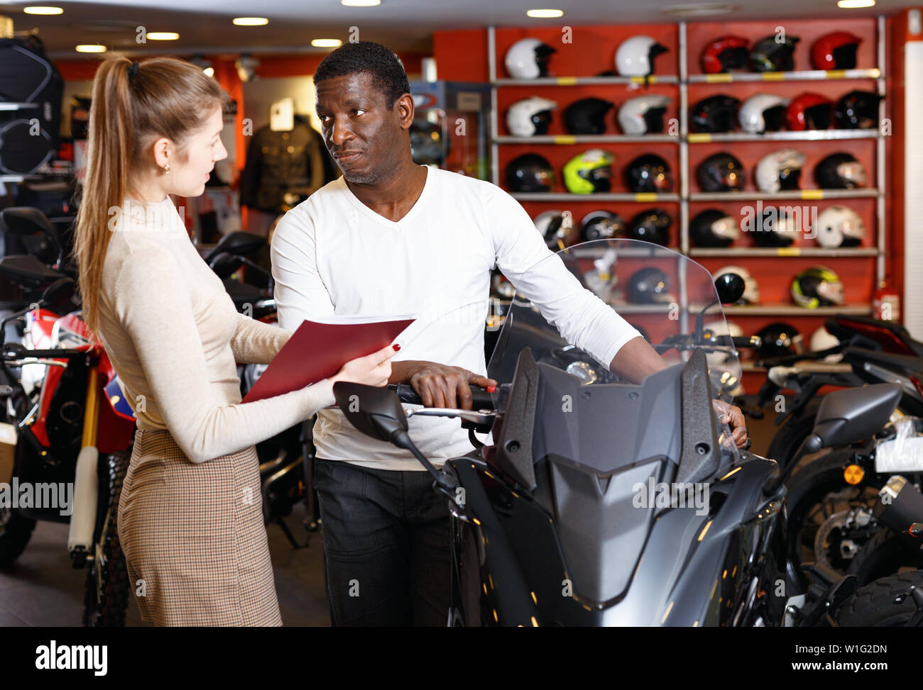 Polite smiling diligent positive female seller communicating with male ...