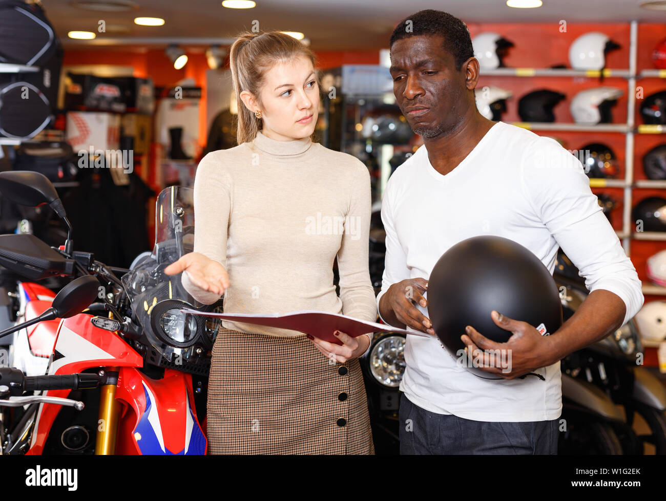 Polite smiling glad positive female seller communicating with male ...