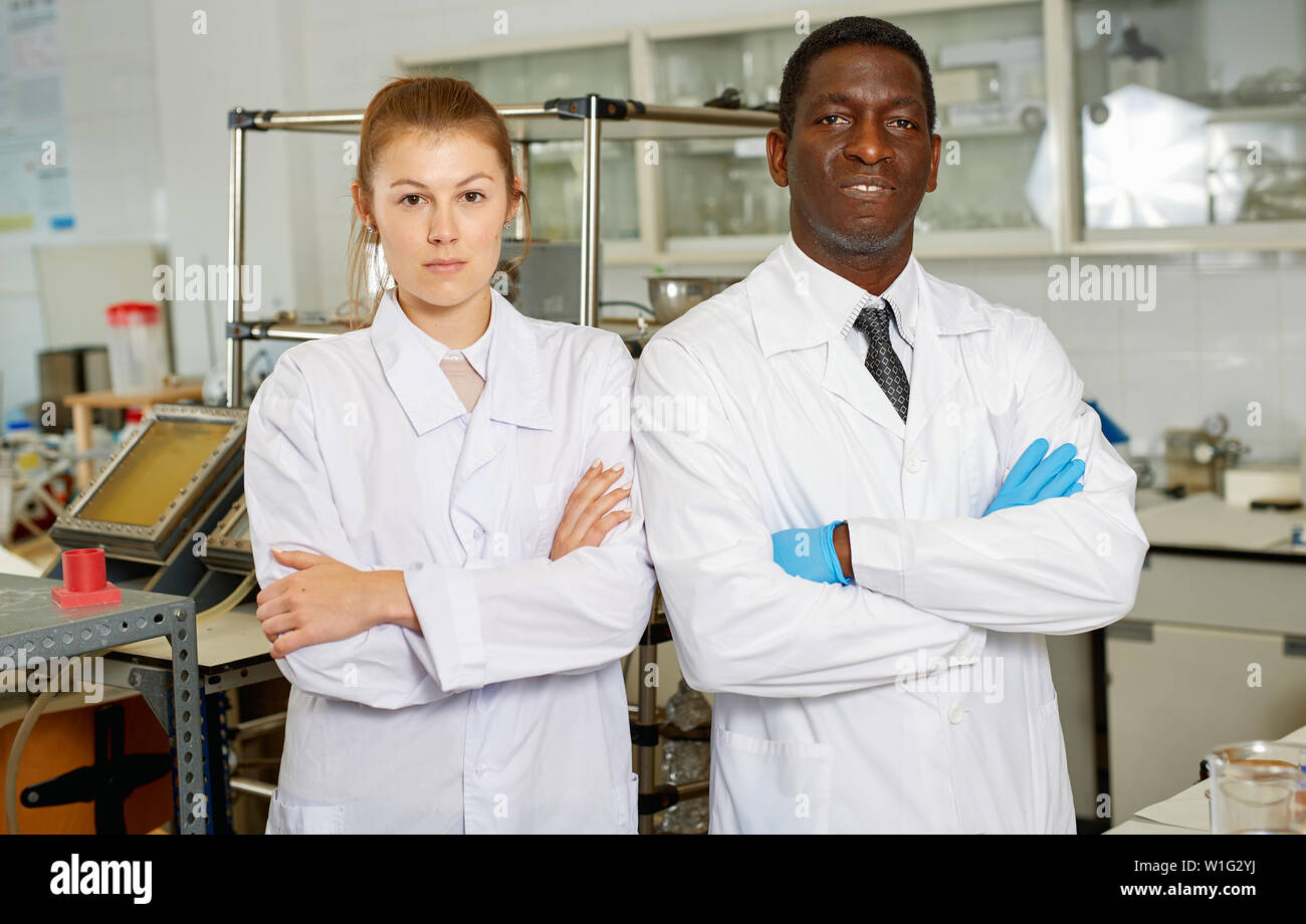 Experienced male and female scientists standing in interior of ...
