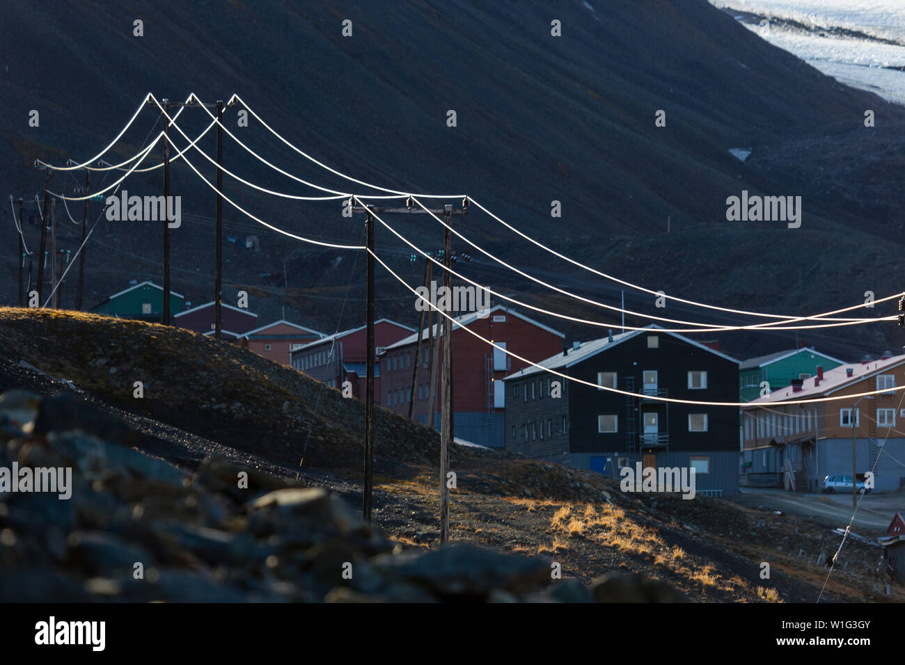 overview of longyearbyen, colored houses, power line with mountains in ...