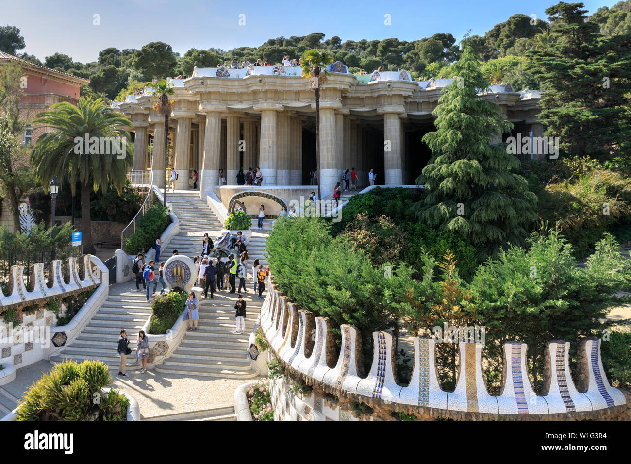 Tourists and people walking around the entrance steps of Park Güell ...