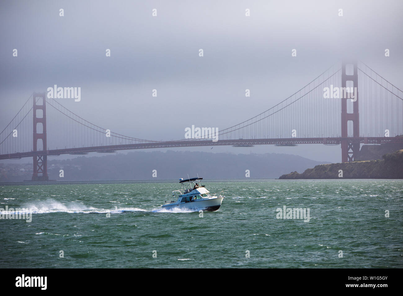 Boat navigating San Francisco Bay with Golden Gate Bridge behind. Taken ...