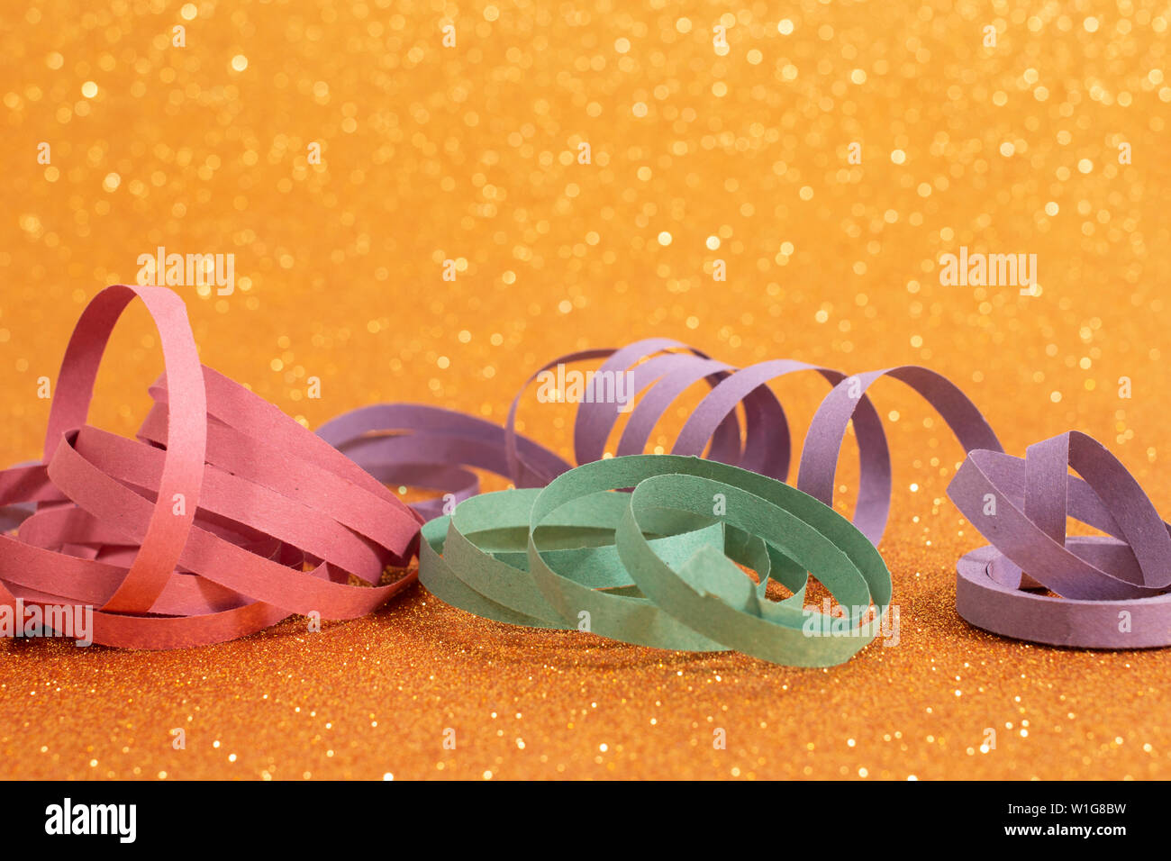 Mixed colorful streamers on a golden background Stock Photo - Alamy