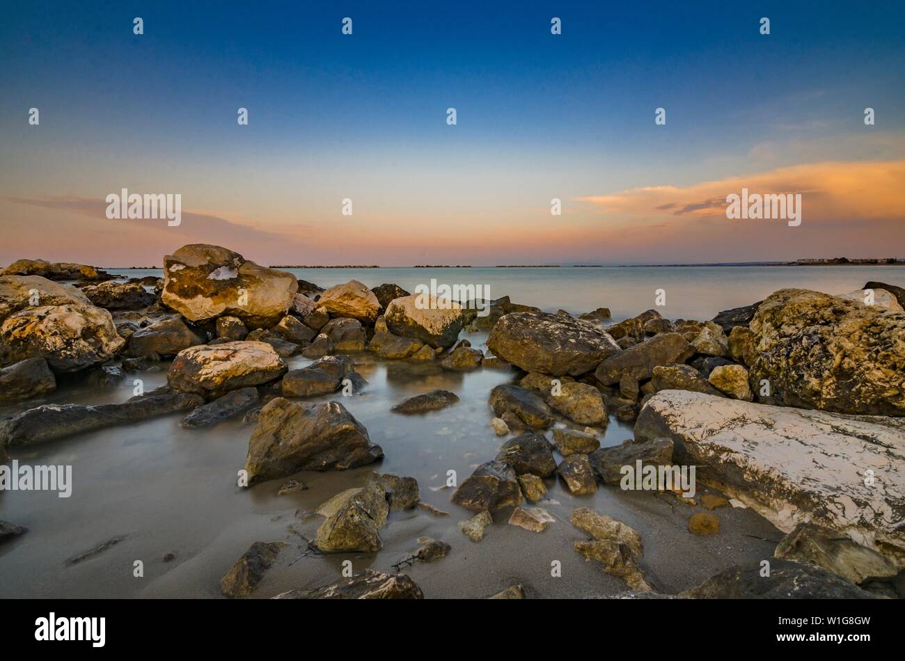 Beautiful coastal seascape with rocks in the foreground at sunset Stock ...