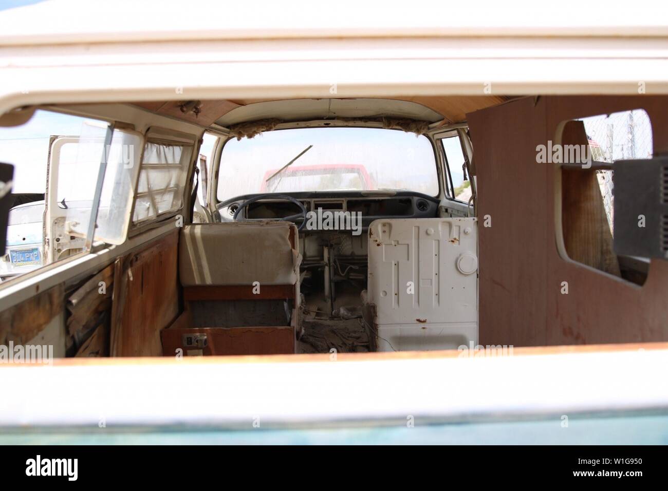 Inside of an old rusty broken beach vagon with worn out cabin seats ...
