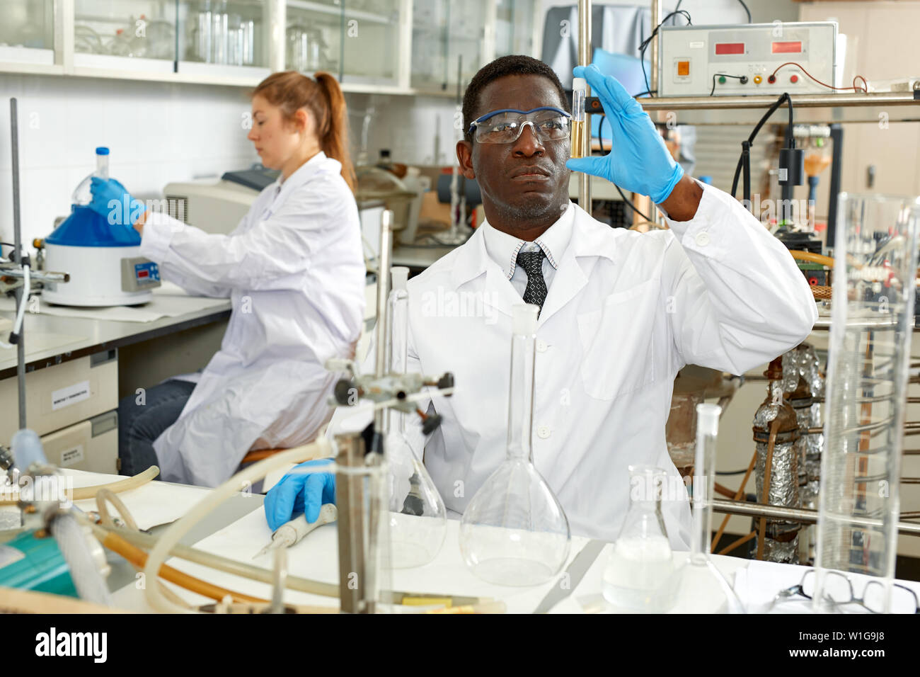 Man proffesional lab scientist in glasses working with reagents and ...