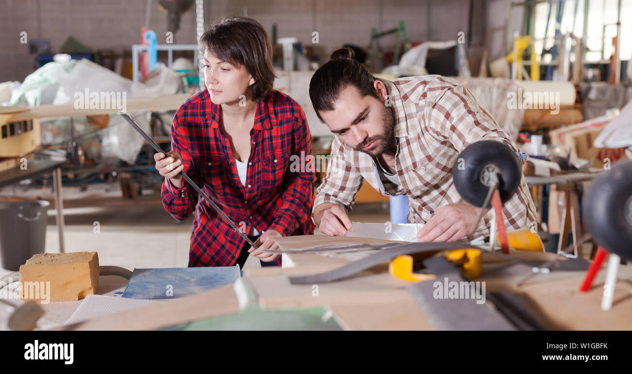 Positive couple enjoying their hobbies - modeling light airplanes in ...