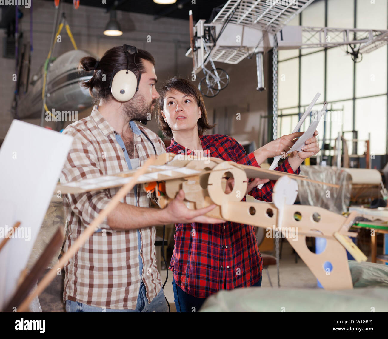 Team of aircraft enthusiasts working in workshop on creating of ...