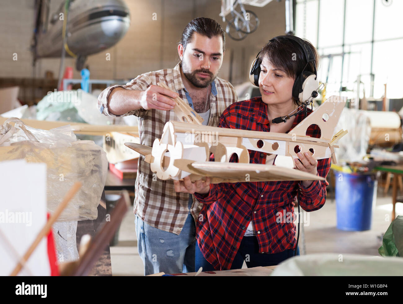 Team of aircraft enthusiasts working in workshop on creating of ...