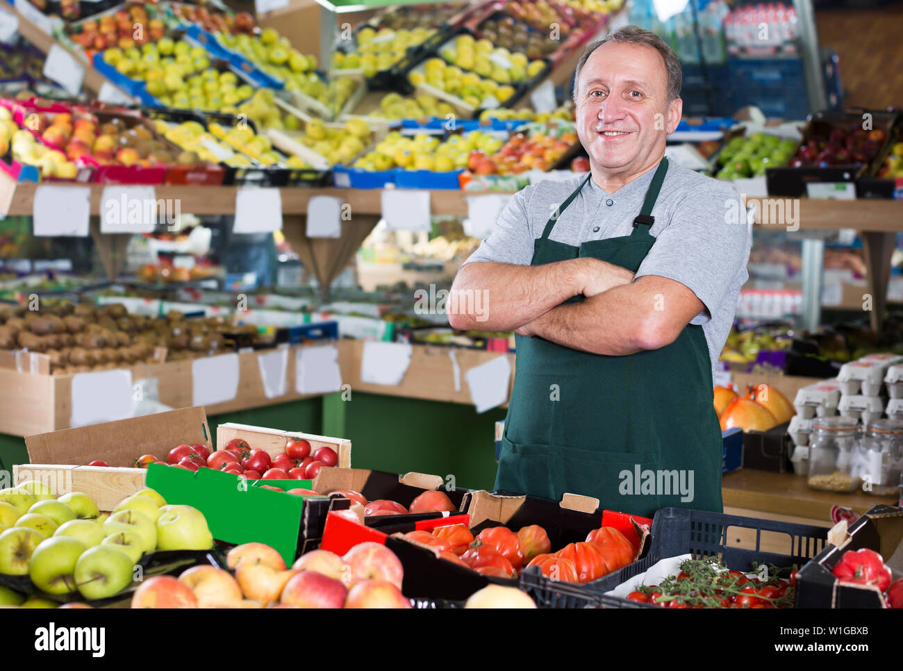 Portrait of nice man seller who is standing on his workplace in ...