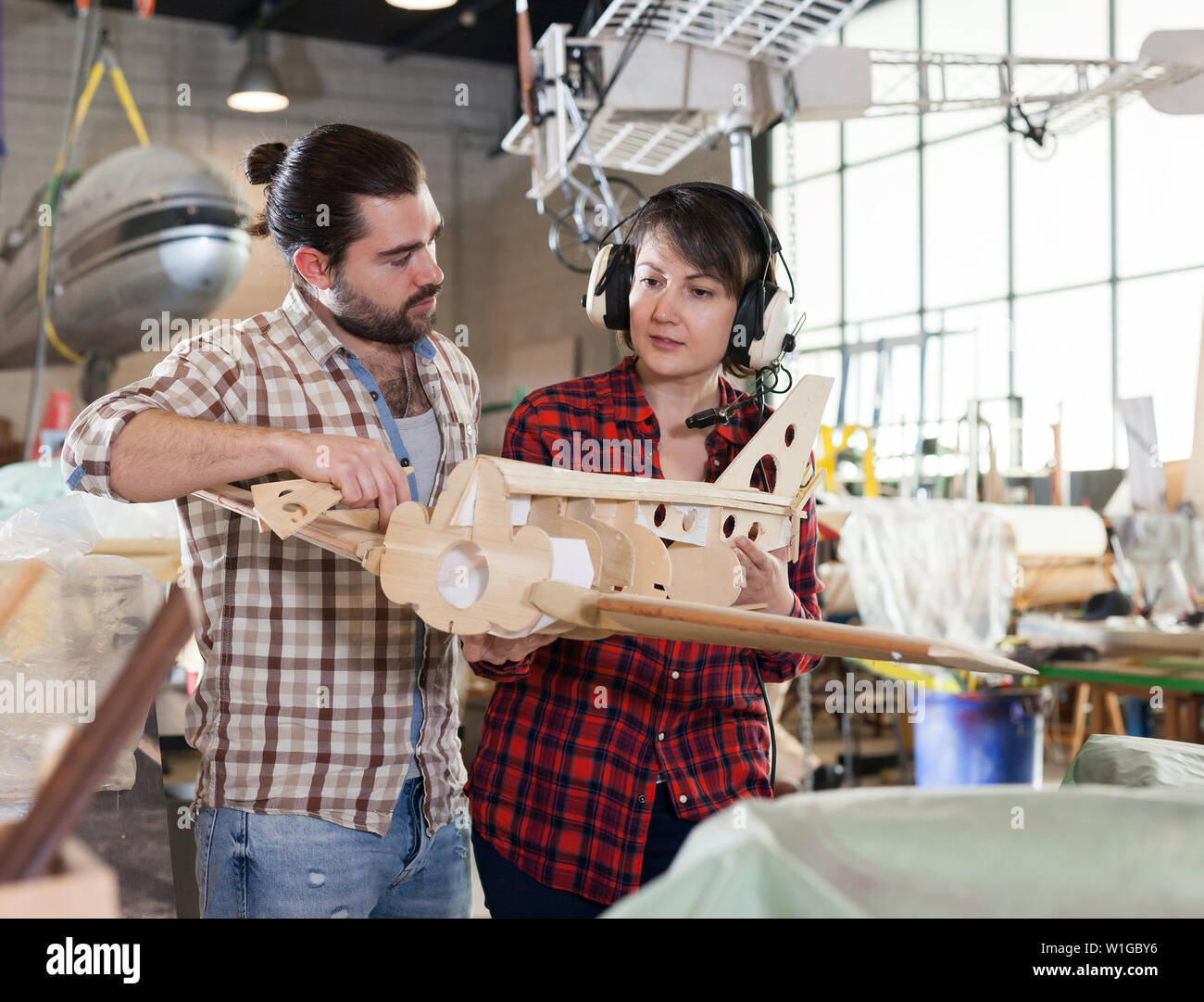 Team of aircraft enthusiasts working in workshop on creating of ...
