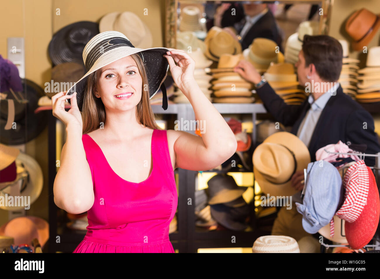 adult smiling woman try on hatinator hat in shopping mall Stock Photo ...