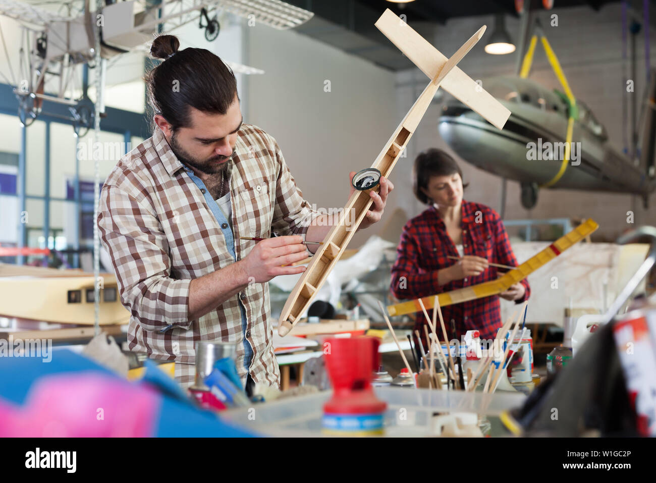 Happy male aircraft enthusiast working in workshop on creating of ...