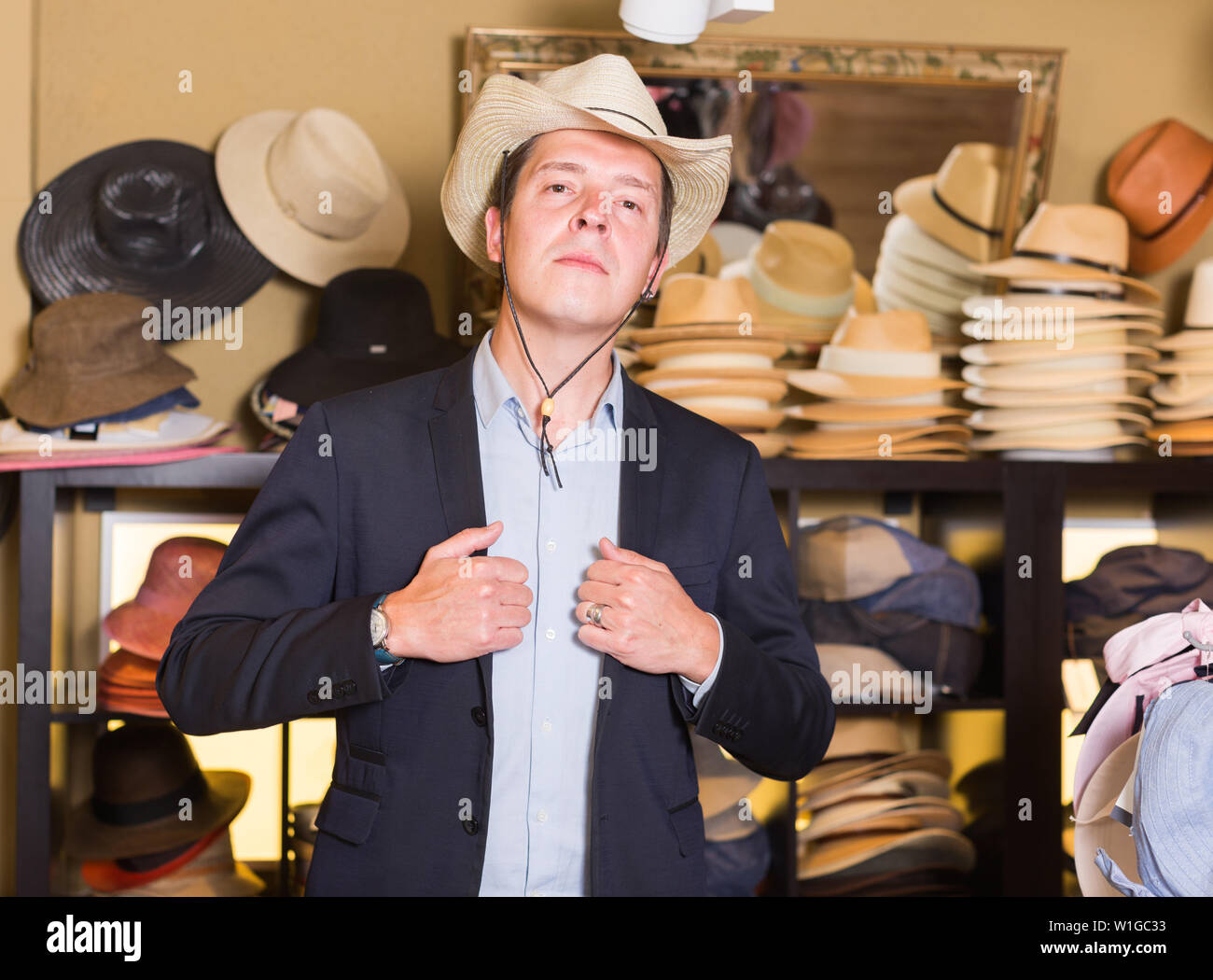 happy american adult male try on western hat at the shopping center ...