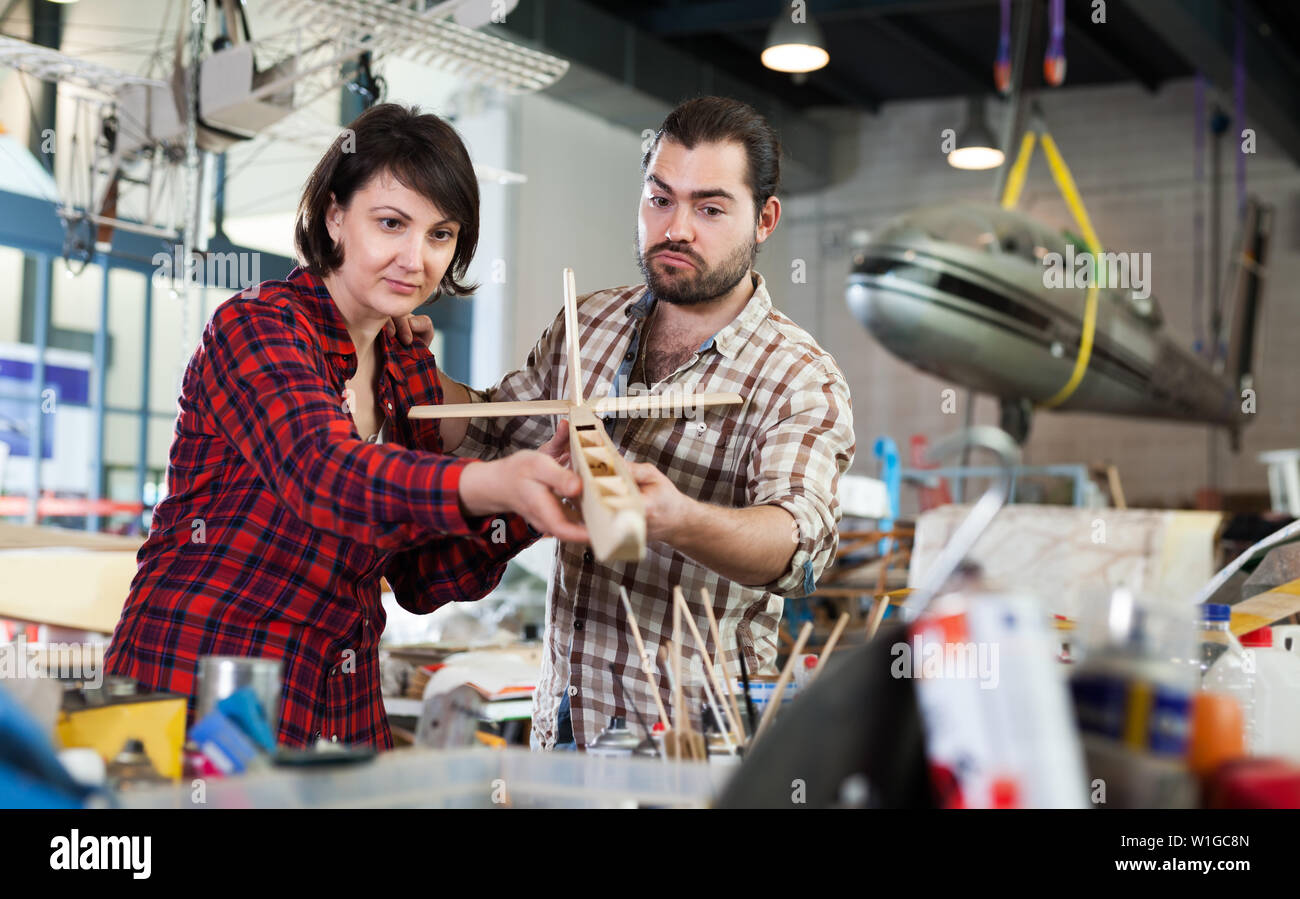 Female and male hobbyists engaged in modeling plane models in aircraft ...