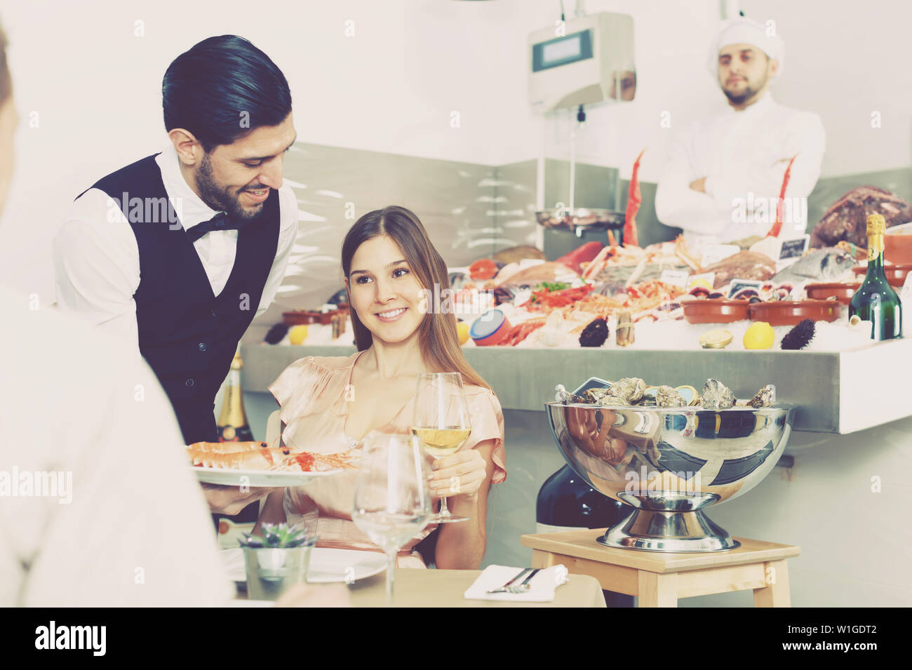 Girl nicely in fish restaurant spending time with man colleague over ...