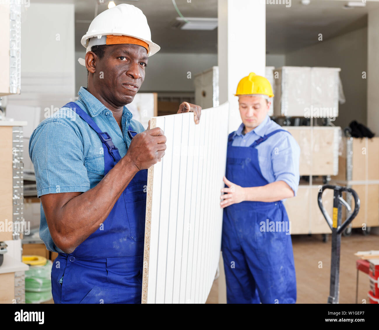Two male builders working at indoors building site Stock Photo - Alamy