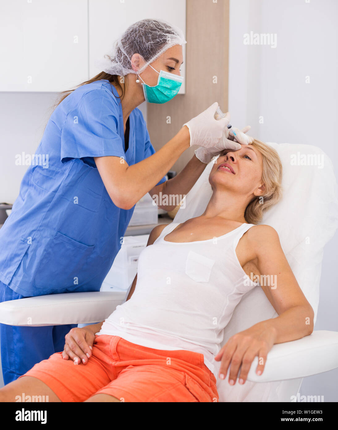 Portrait of woman during beauty facial injections in medical esthetic ...