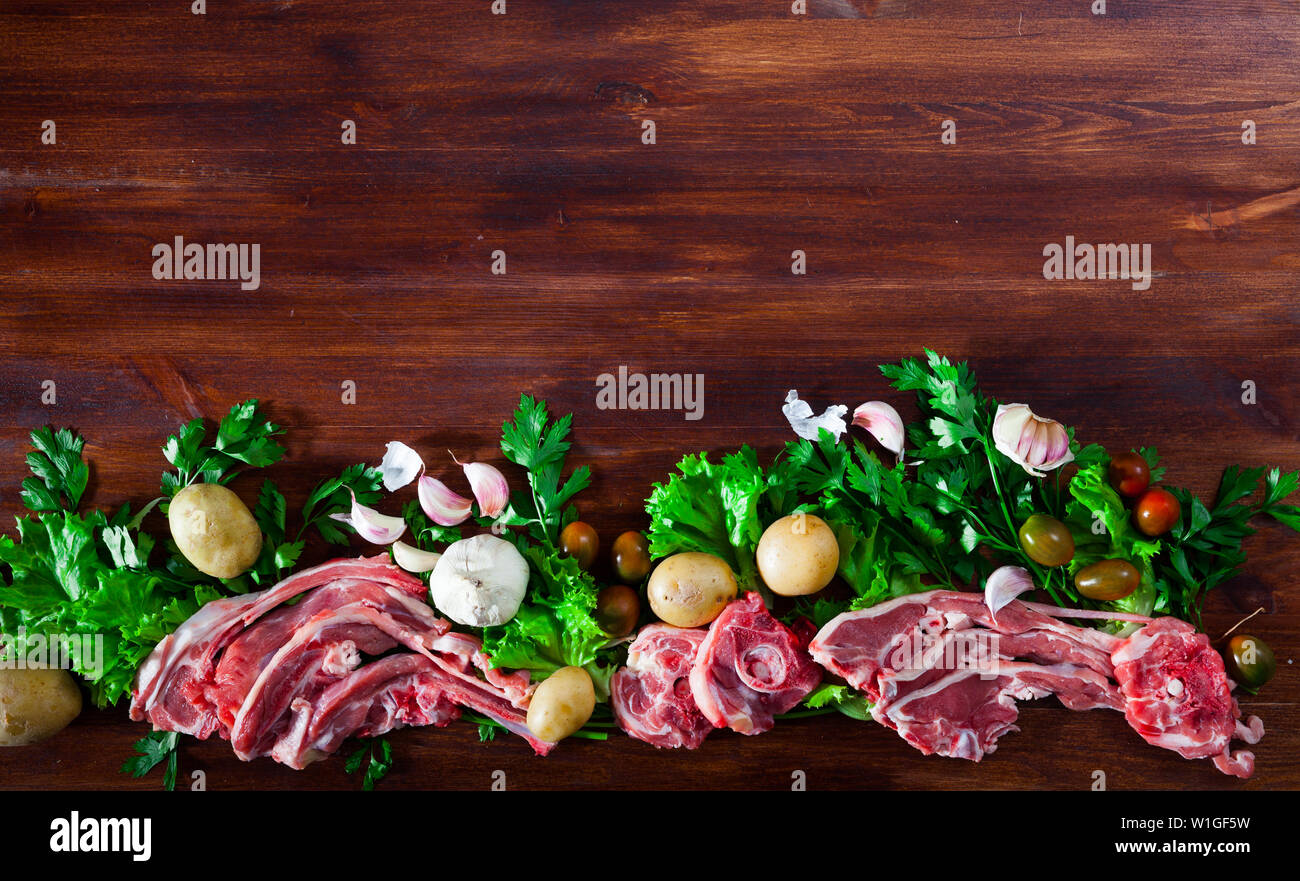 Raw mutton and vegetables assortment on natural wooden background ...