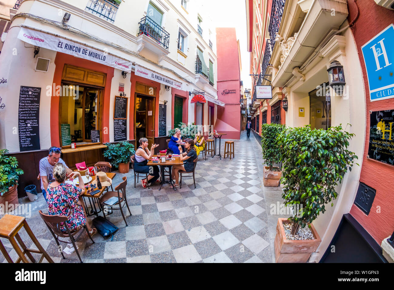 Fisheye view of people at outdoor cafe in the Barrio de Santa Cruz or ...