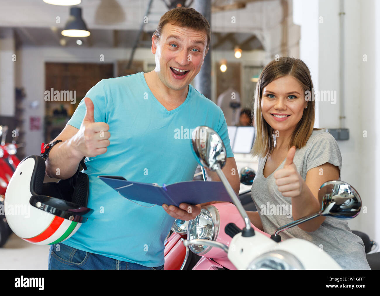 Man and woman is pleased with the purchase is near motorcycles in the ...