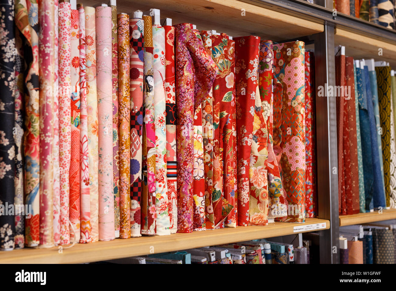 View of cloth rolls of different colors and patterns on shelves in ...