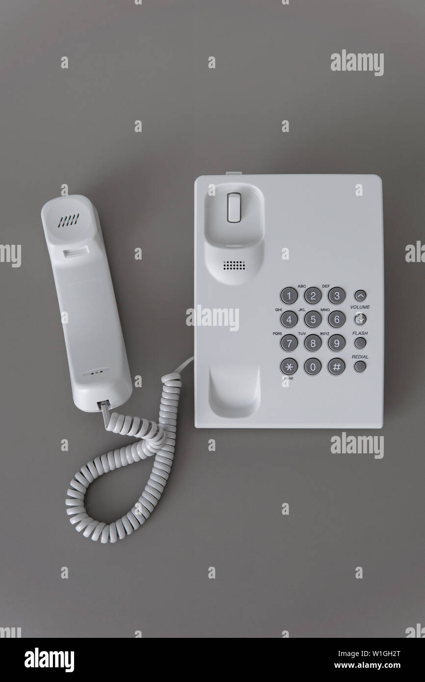 Modern white landline office phone with a hook. Technical support ...