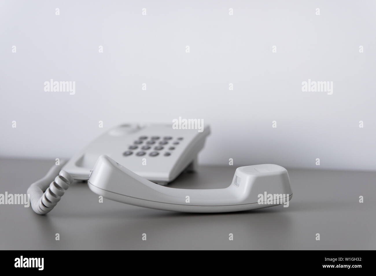Modern white landline office phone with a hook. Technical support ...