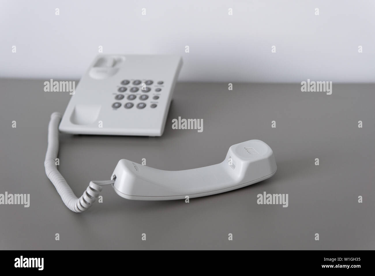 Modern white landline office phone with a hook. Technical support ...