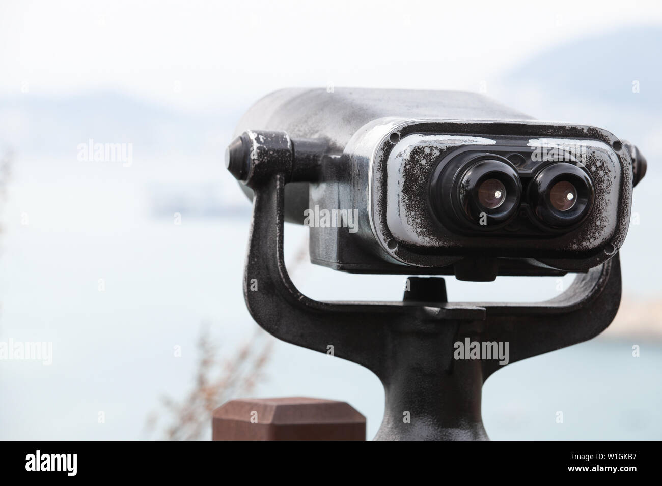 Weathered binocular telescope on a rotating base mounted on a mountain ...