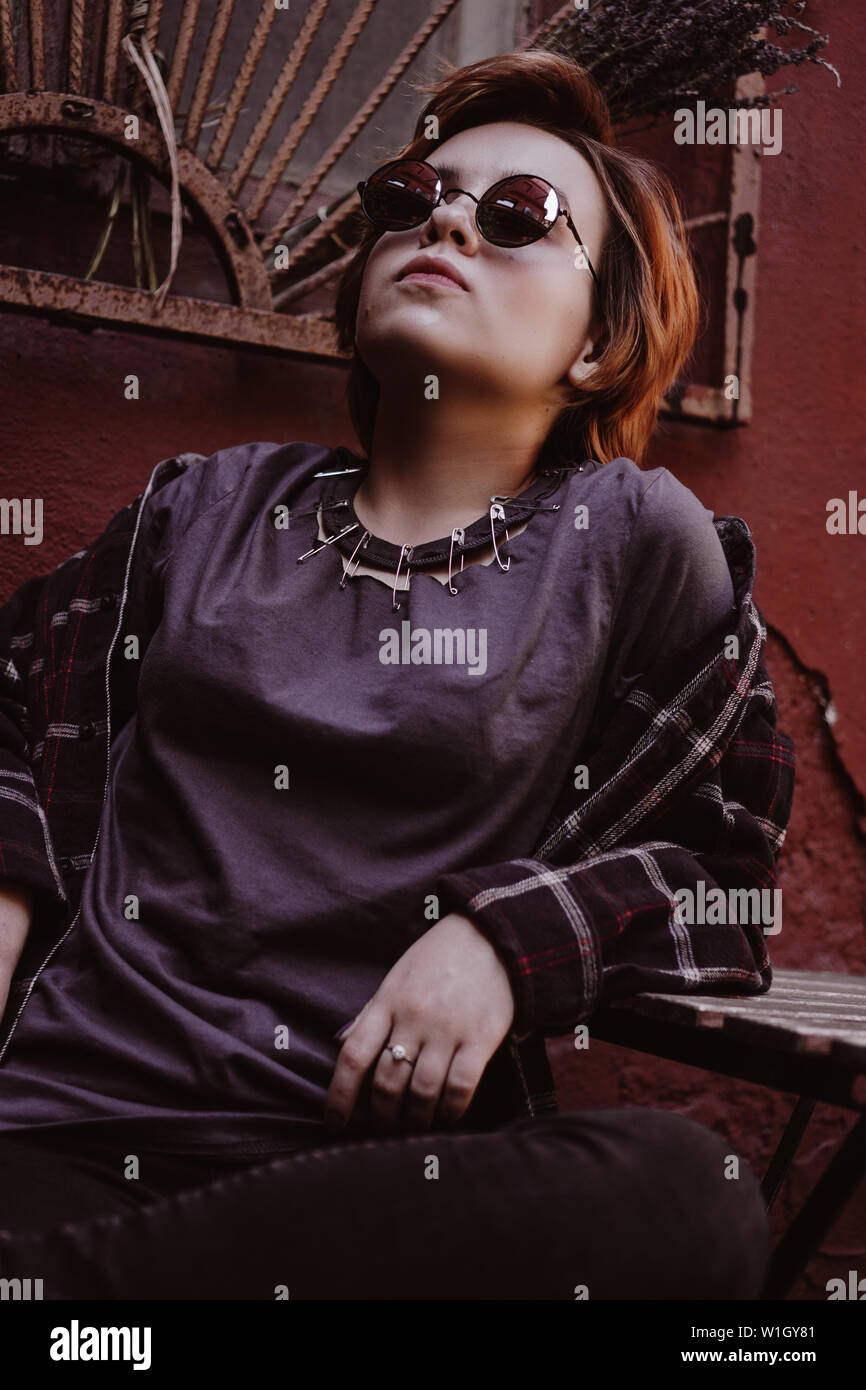 Portrait of attractive cheeky woman with short red hair in sunglasses ...