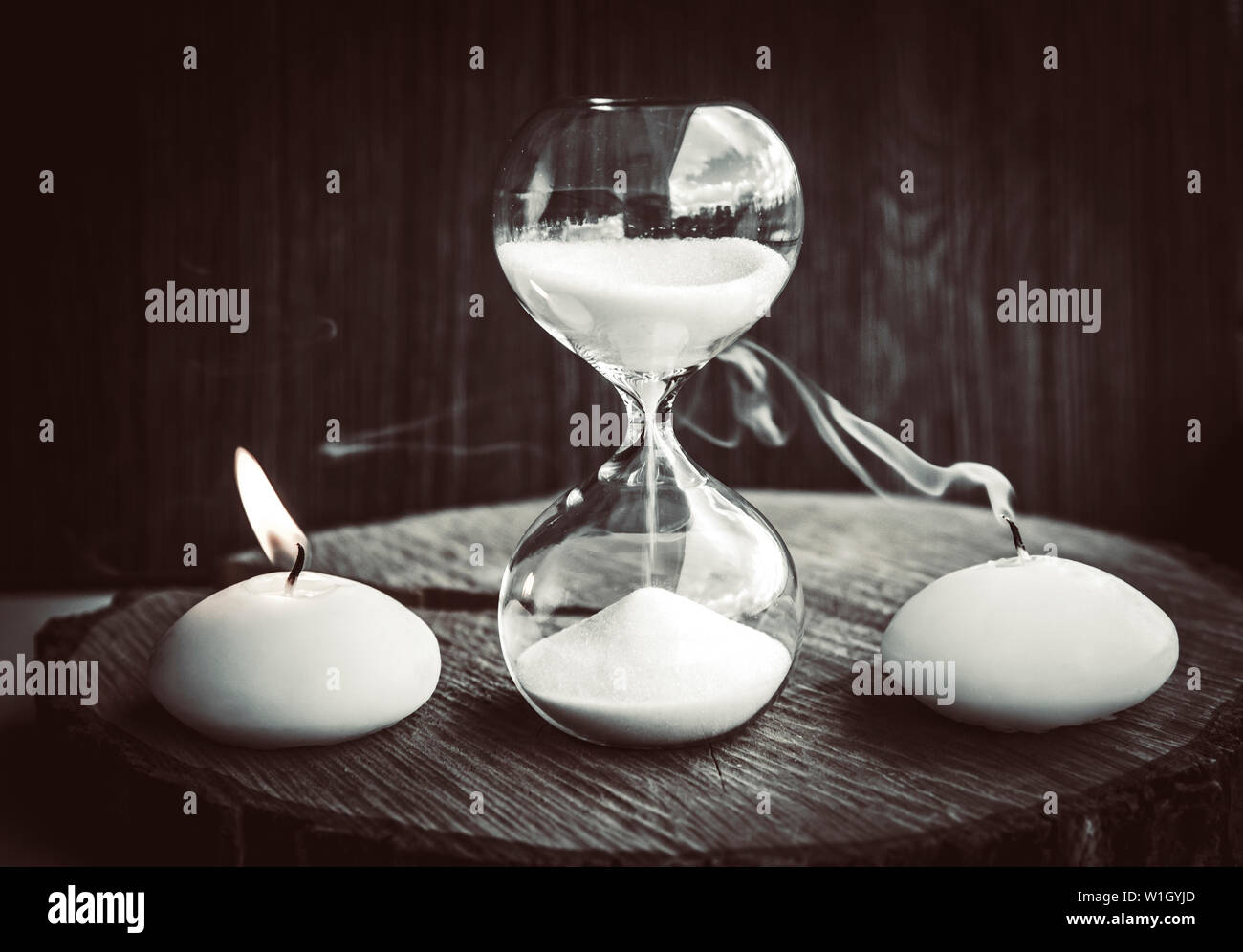 Time running out, life and death concept. One candle burning with flame ...
