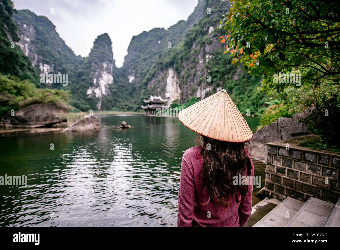 Vietnamese Girl with straw hat in Trang An Scenic Landscape formed by ...