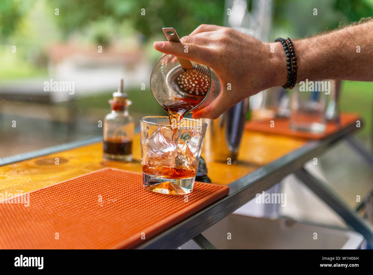 Barman pours whiskey in a glass at the bar Stock Photo - Alamy