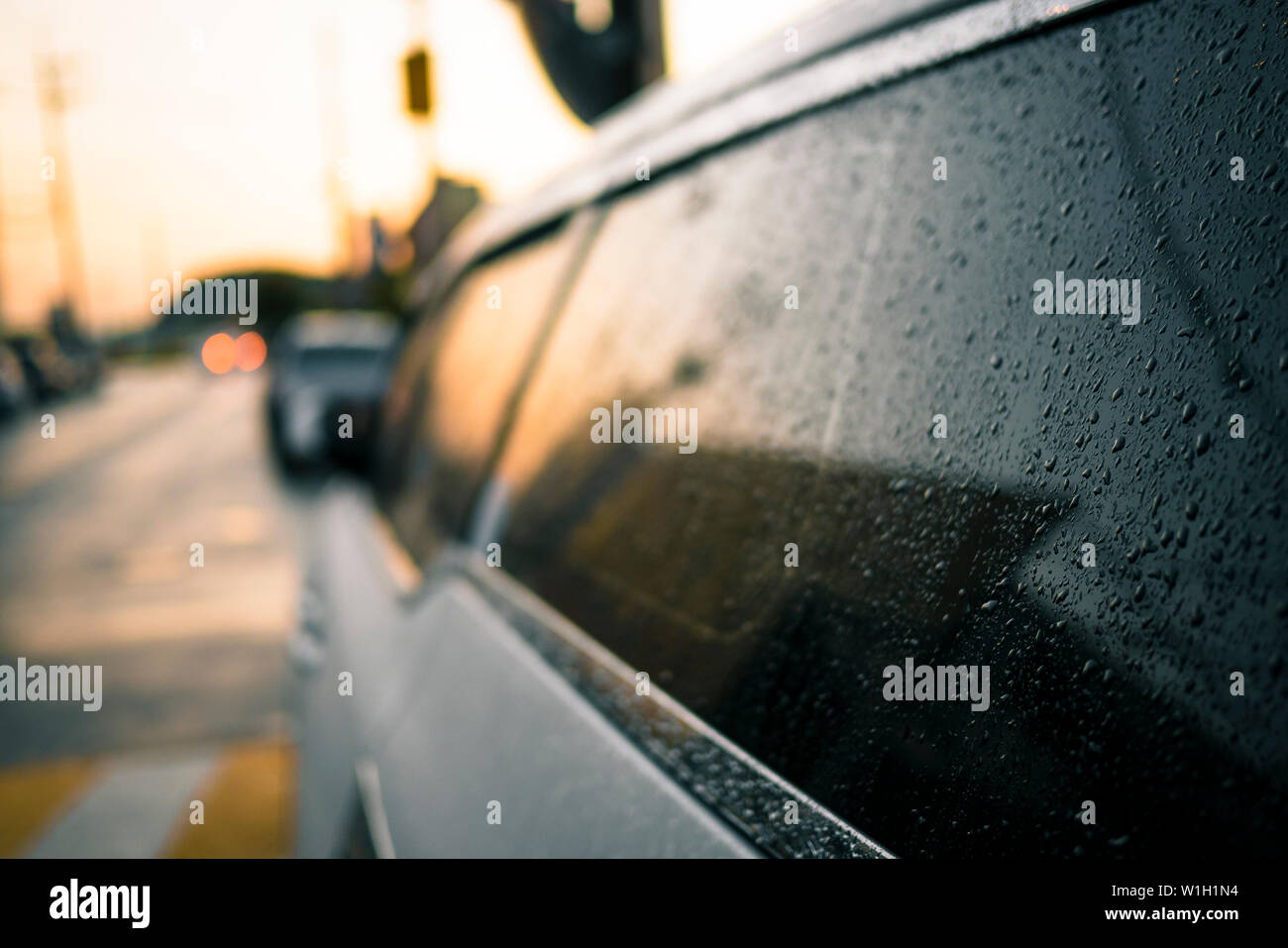 the tinted glass of the car is covered with drops after the rain ...