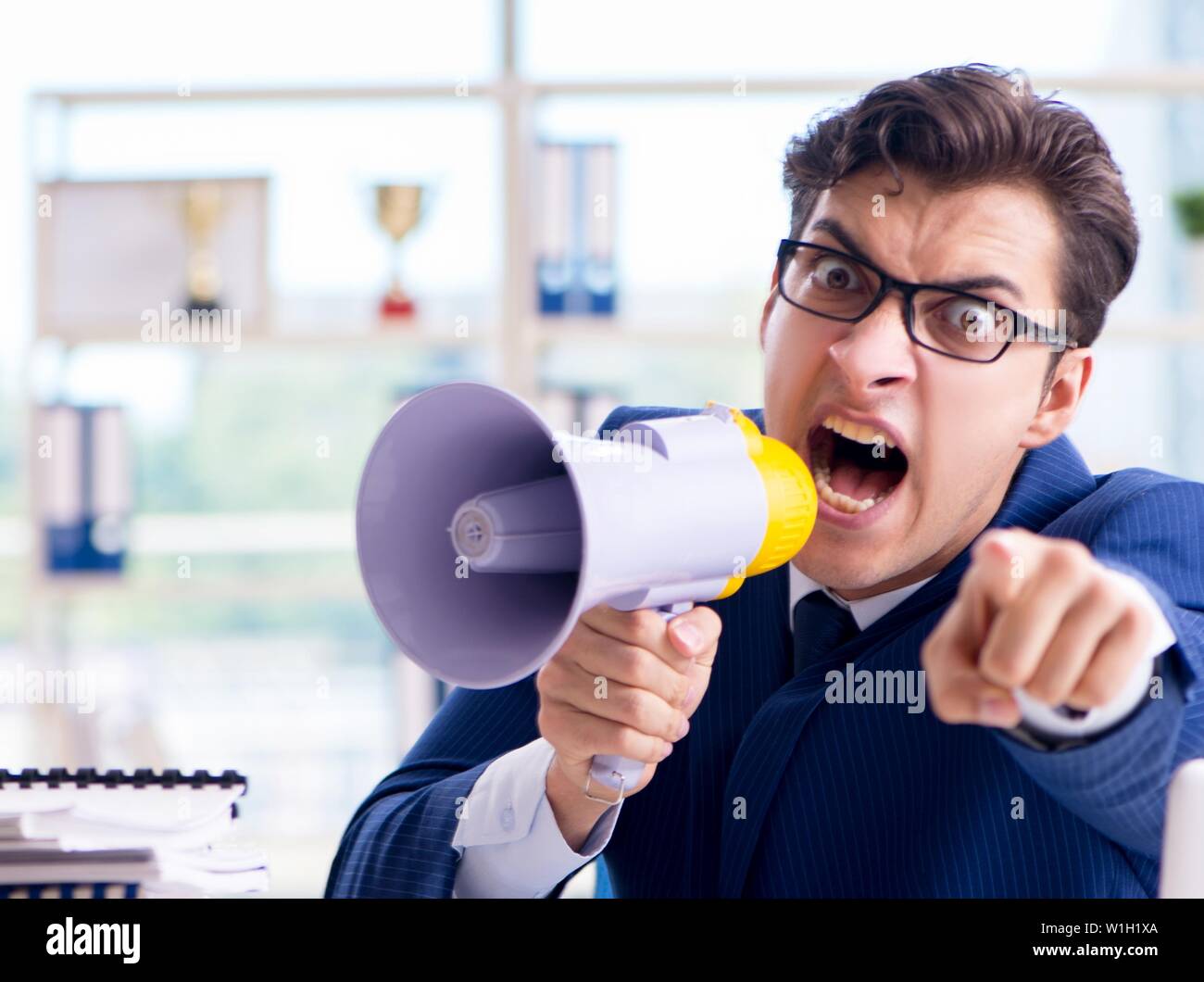 Angry aggressive businessman with bullhorn loudspeaker in office Stock ...