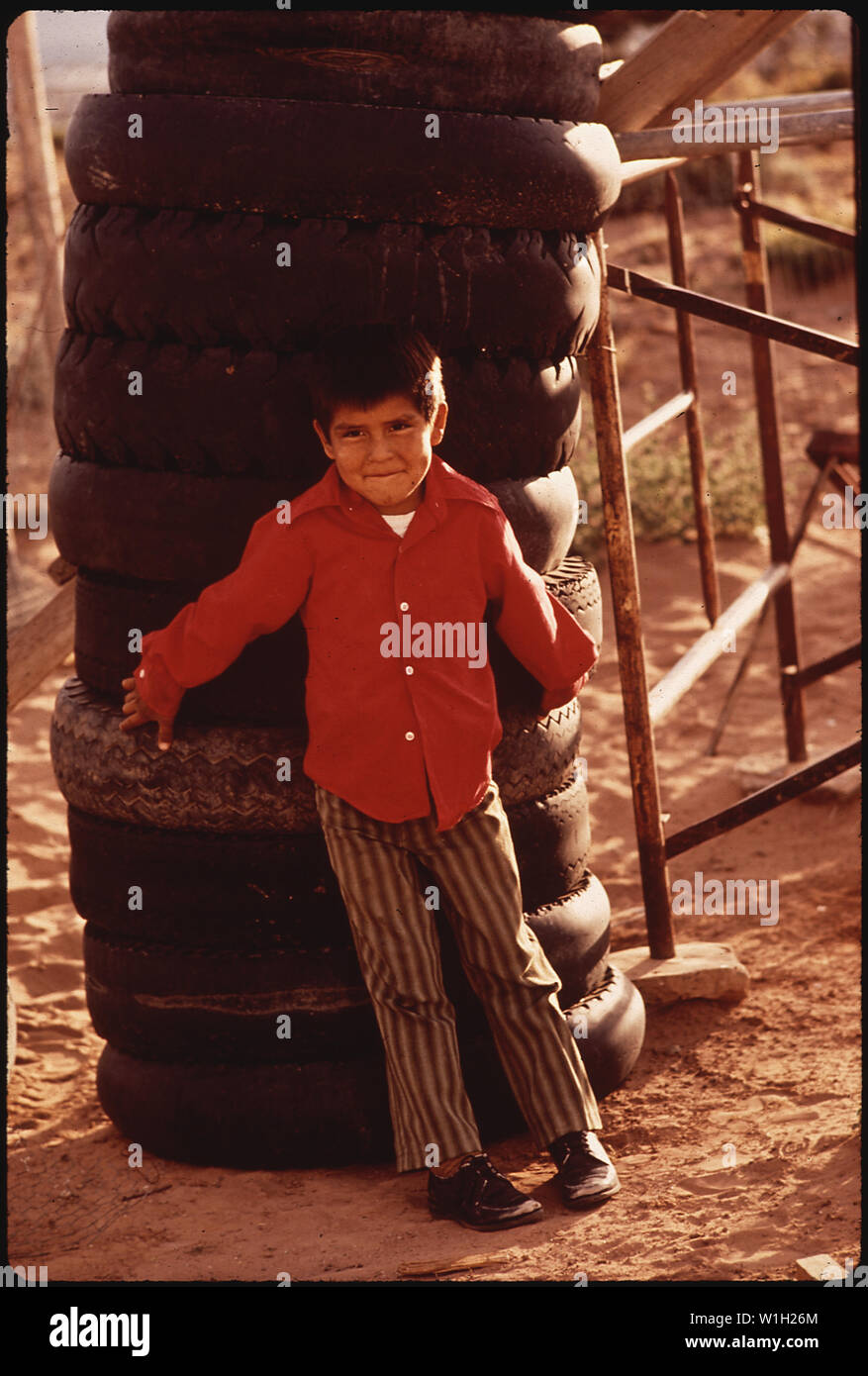 NAVAHO BOY LEANS AGAINST TOWER OF DISCARDED TIRES. LACK OF DISPOSAL ...