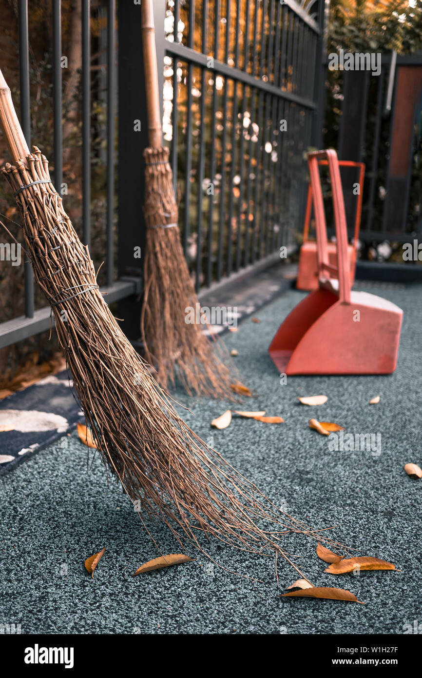 Beautiful brooms with red shovels are on the street. street cleaning of ...