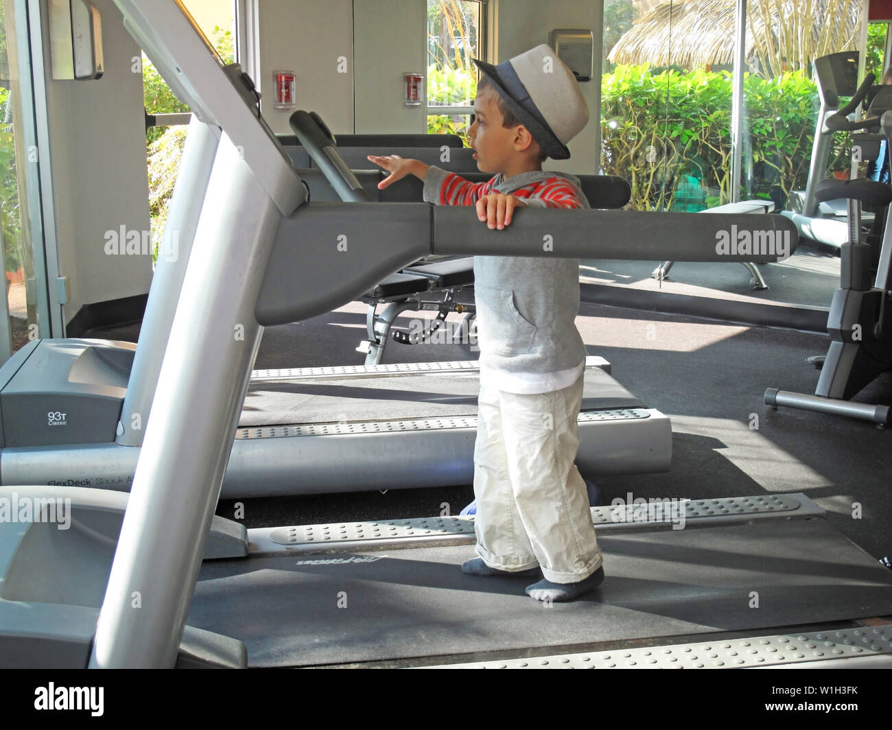 Young boy with a fedora on a treadmill in a gym Stock Photo - Alamy